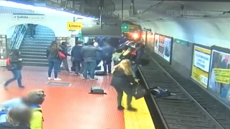 Video shows moment oncoming train nearly hits woman pushed onto tracks ...
