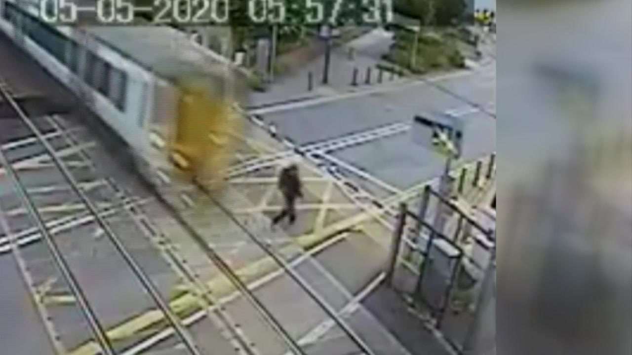 Surveillance video shows train narrowly missing man who wandered across ...