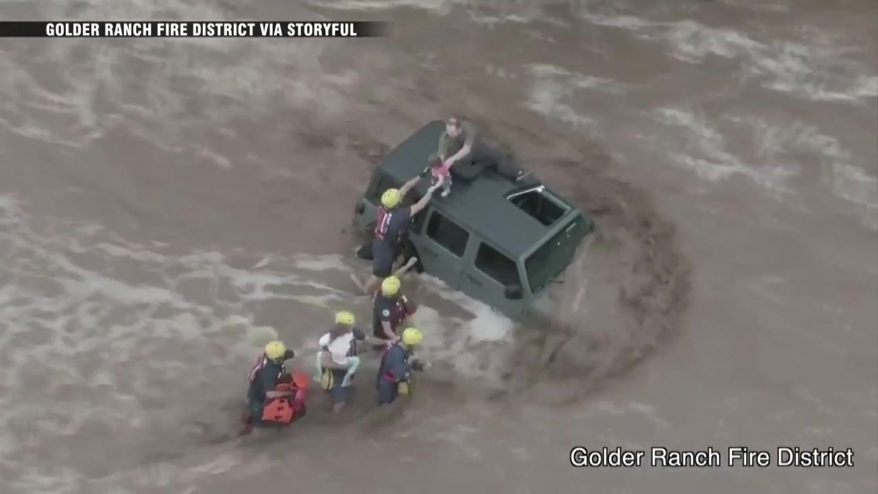 WATCH: Crews rescue dad, 2 young daughters trapped on roof of car amid ...