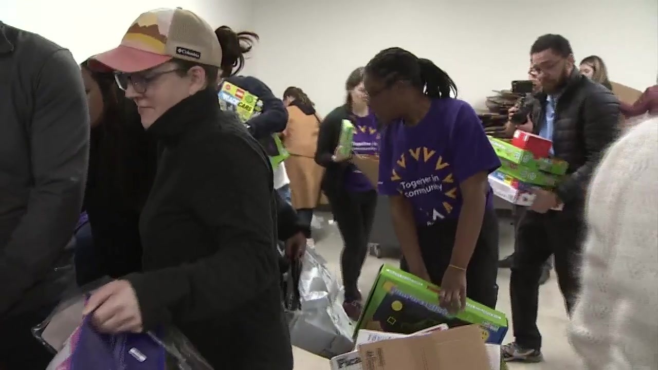 Volunteers with Wonderfund pack presents for kids in need in ...